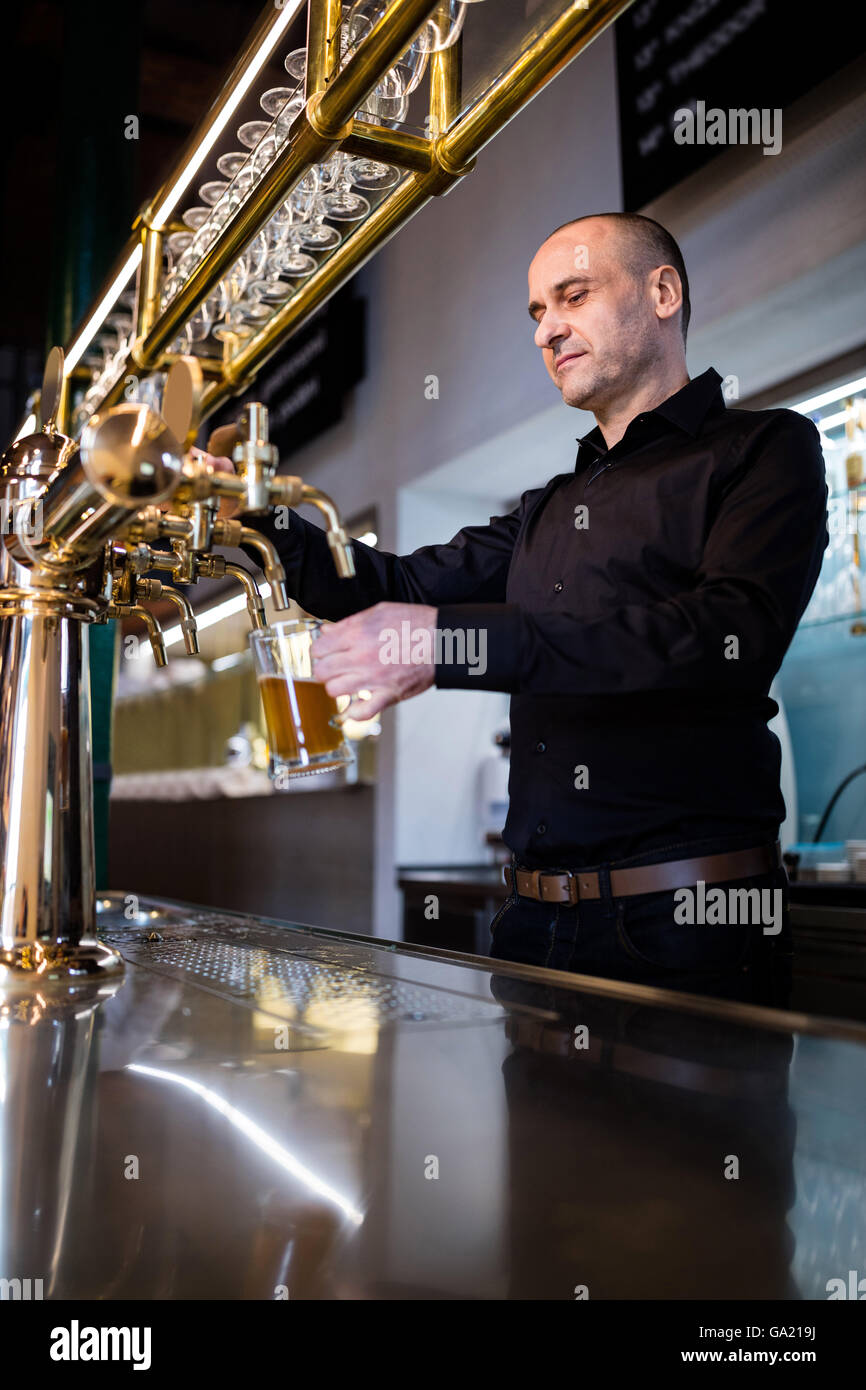 Brewer filling beer in beer glass from beer pump Stock Photo - Alamy