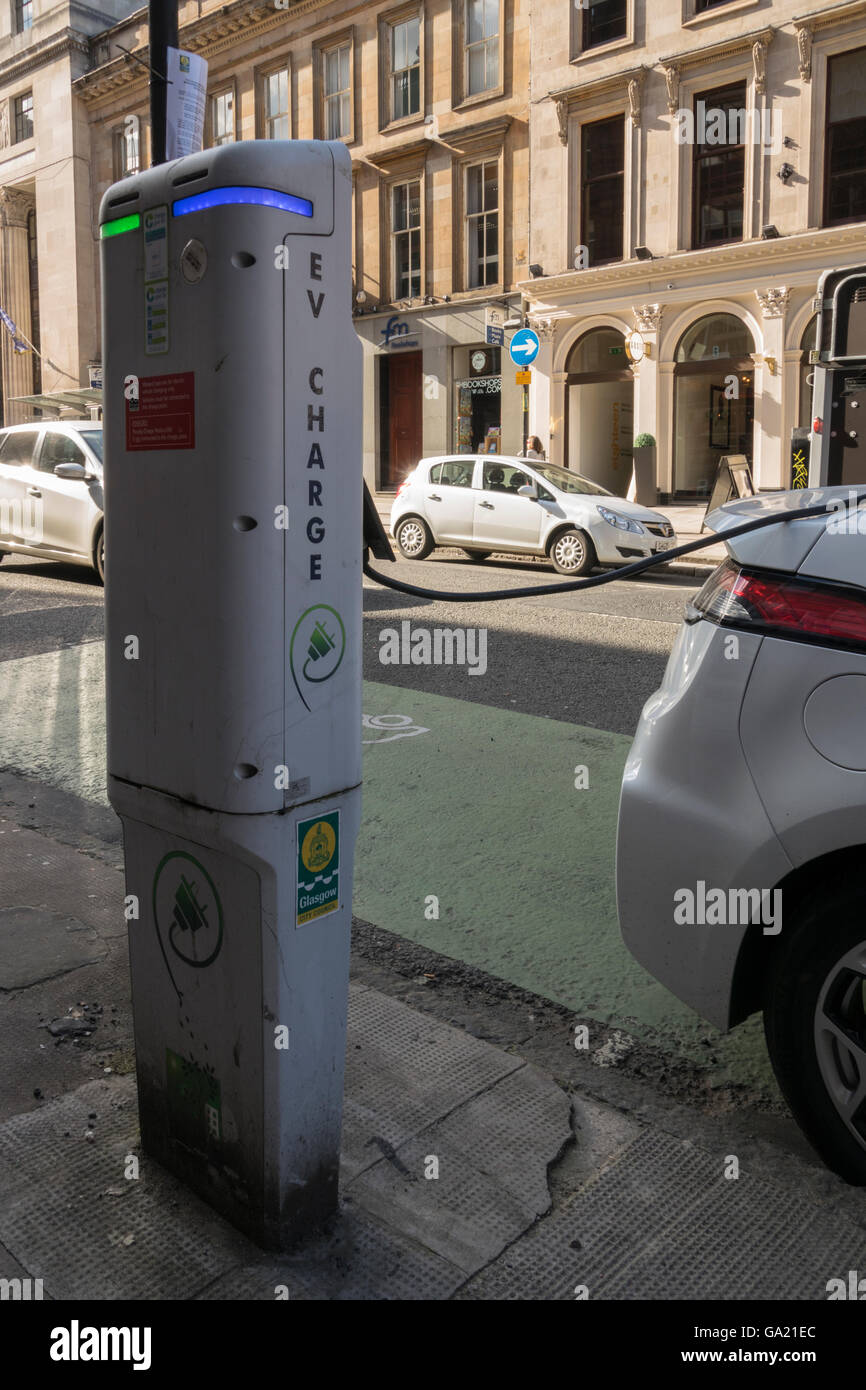 Electric vehicle parked at city centre street charging station, Glasgow ...