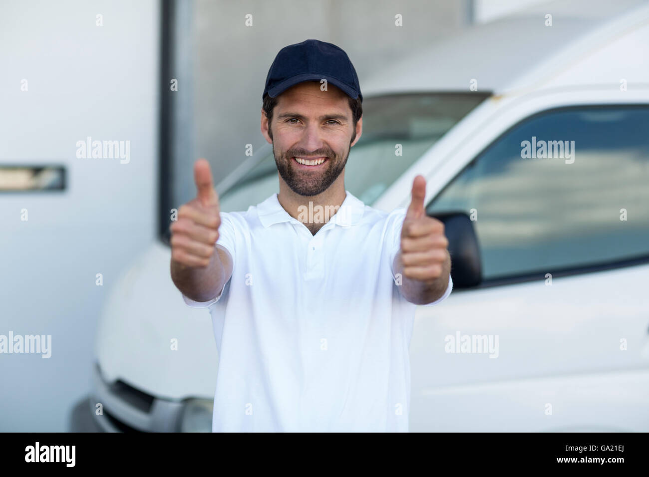 Portrait of delivery man is posing and smiling with thumbs up Stock ...