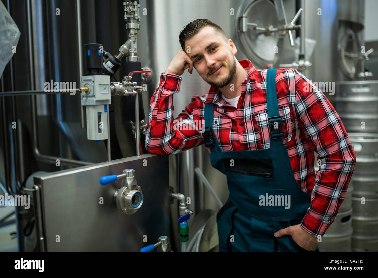 Portrait of maintained worker leaning on machine Stock Photo - Alamy