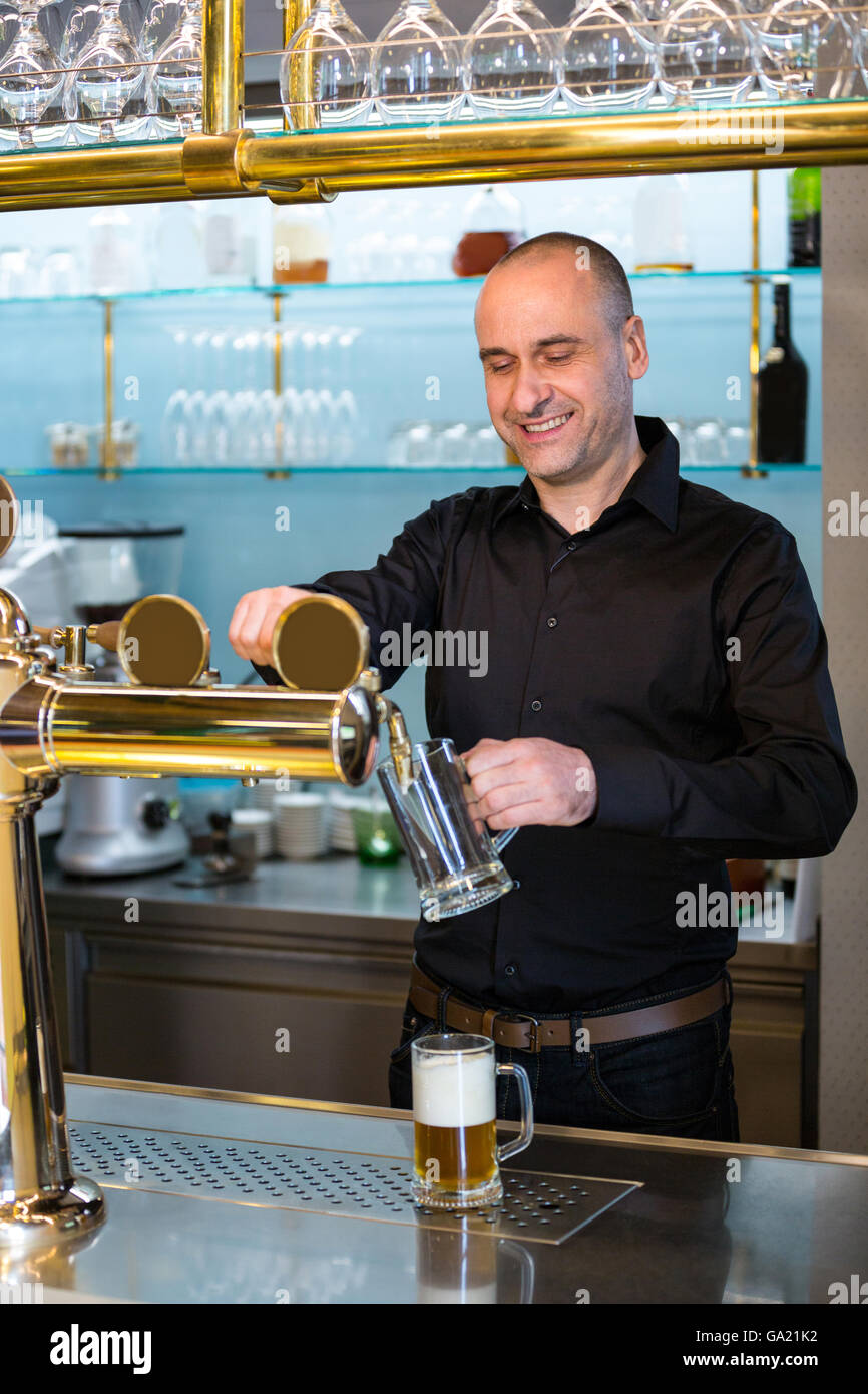 Bar tender filling beer from bar pump Stock Photo - Alamy