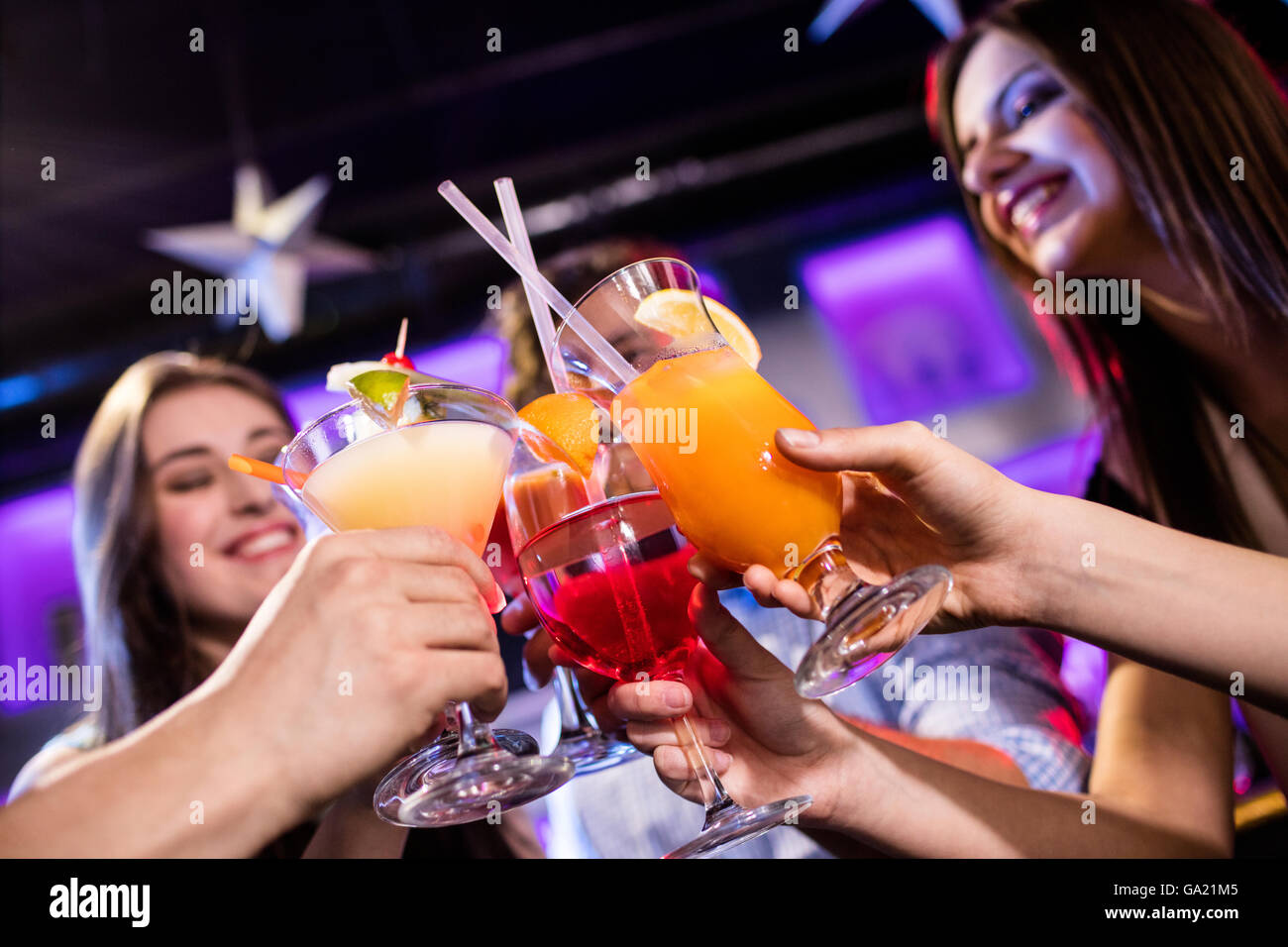 Group of friends toasting cocktail at bar counter Stock Photo - Alamy