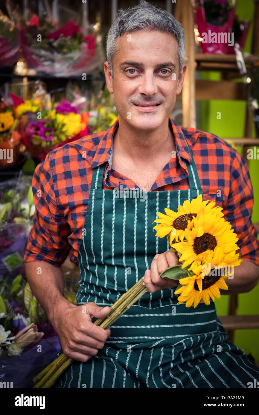 Male florist holding bunch of flowers at flower shop Stock Photo - Alamy