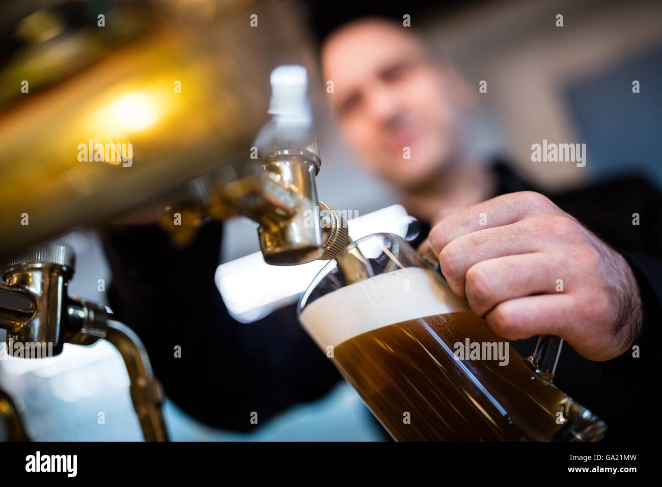 Brewer filling beer in beer glass from beer pump Stock Photo - Alamy