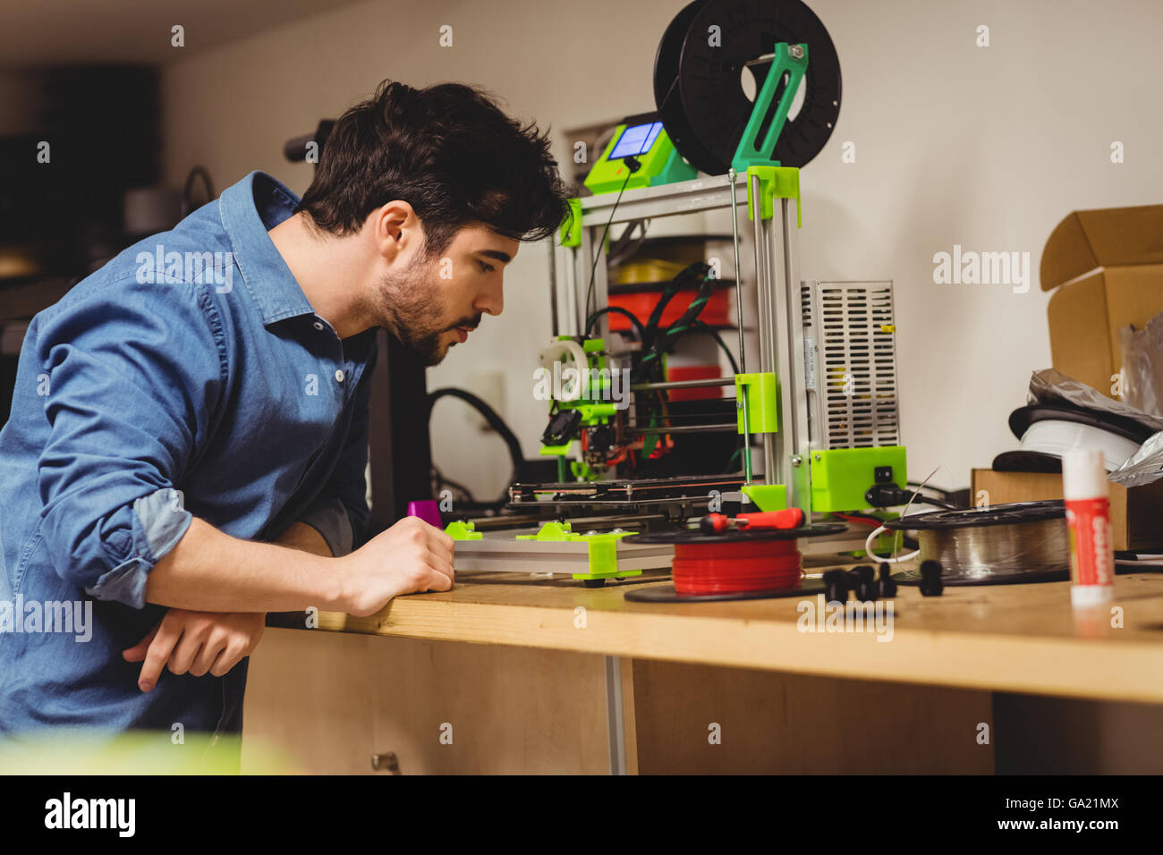 Graphic designer looking at machine Stock Photo - Alamy