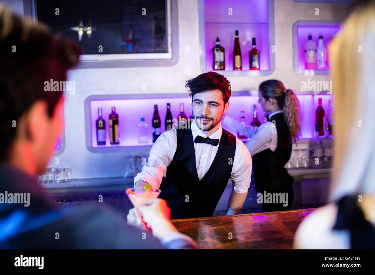 Waiter serving cocktail Stock Photo - Alamy