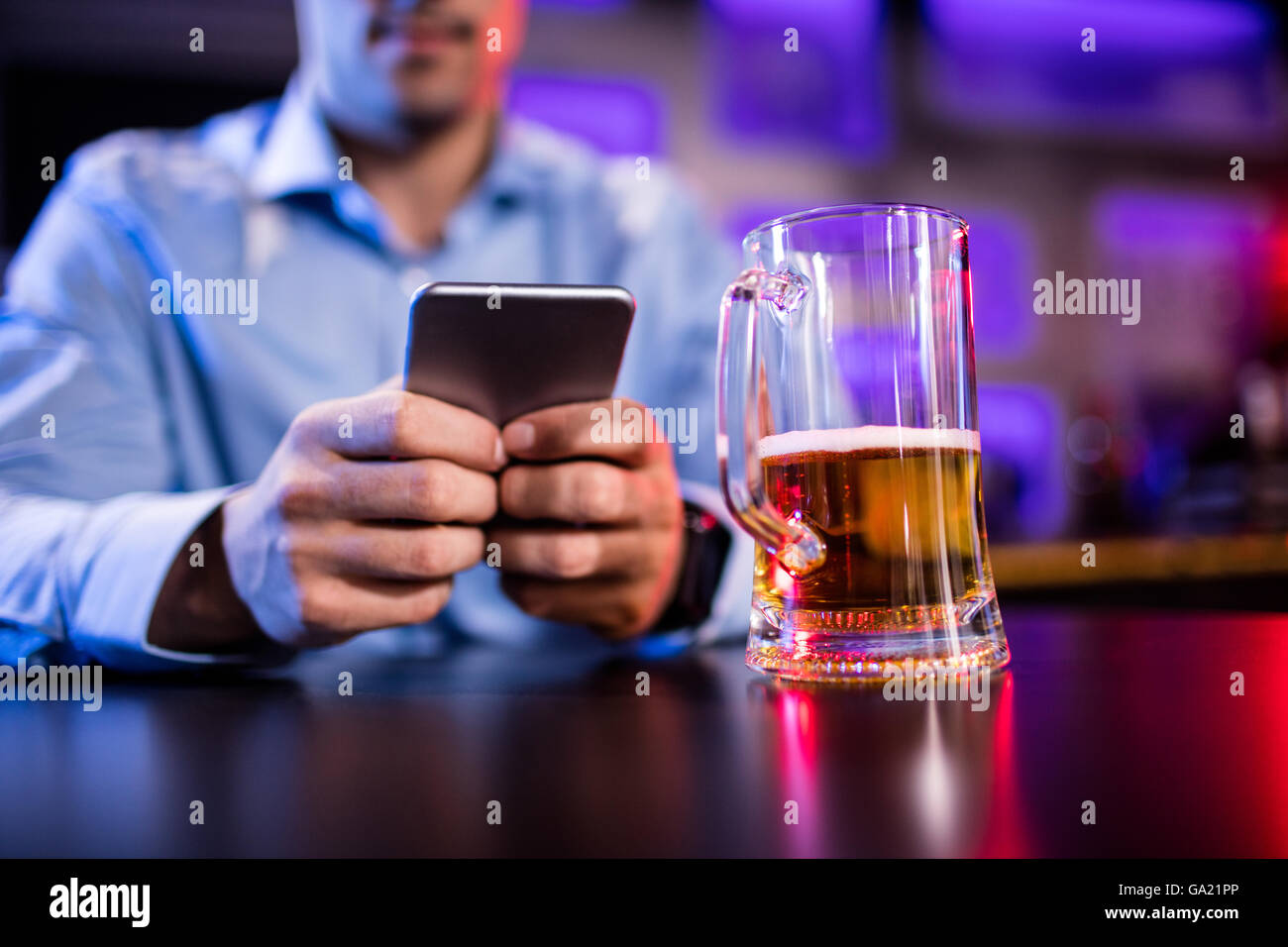 Man using mobile phone at bar counter Stock Photo - Alamy