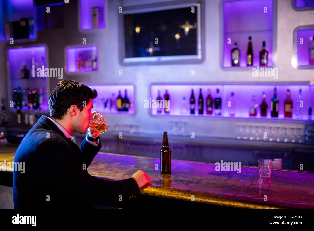 Man drinking alcohol at bar counter Stock Photo - Alamy