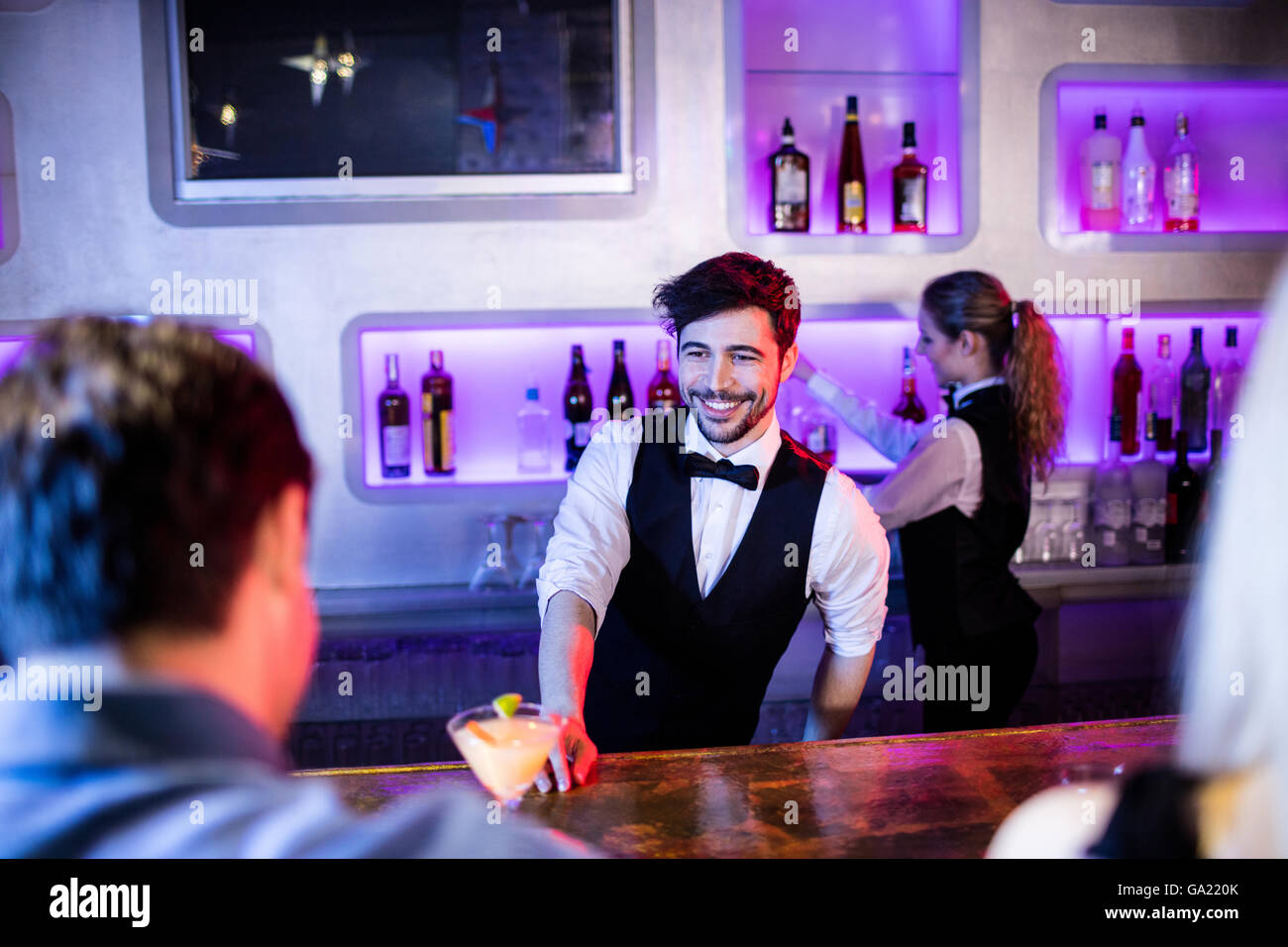 Waiter serving cocktail Stock Photo - Alamy