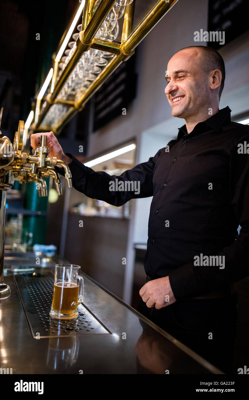 Brewer filling beer in beer glass from beer pump Stock Photo - Alamy