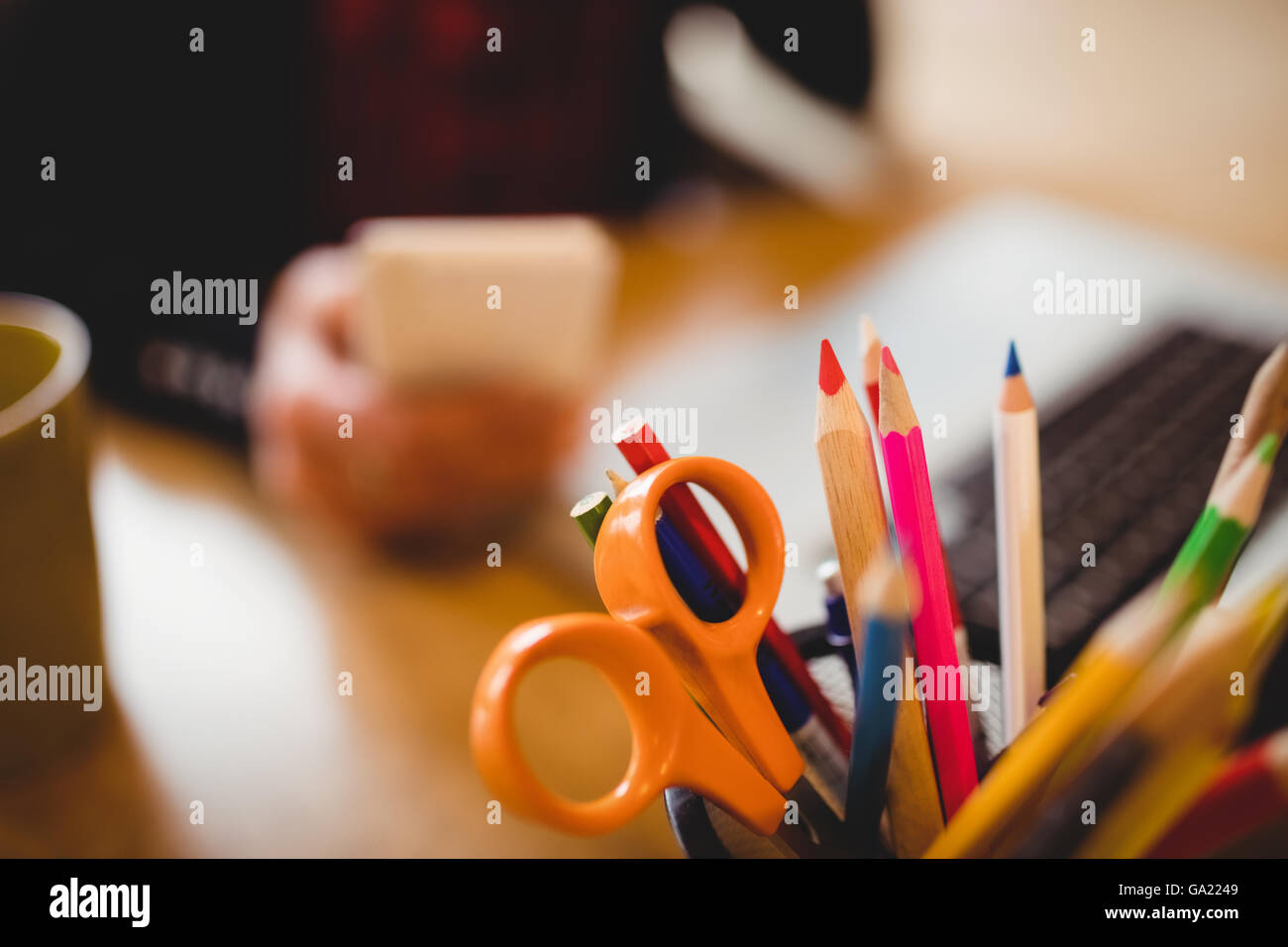 Color pencils and scissor in pen holder Stock Photo - Alamy