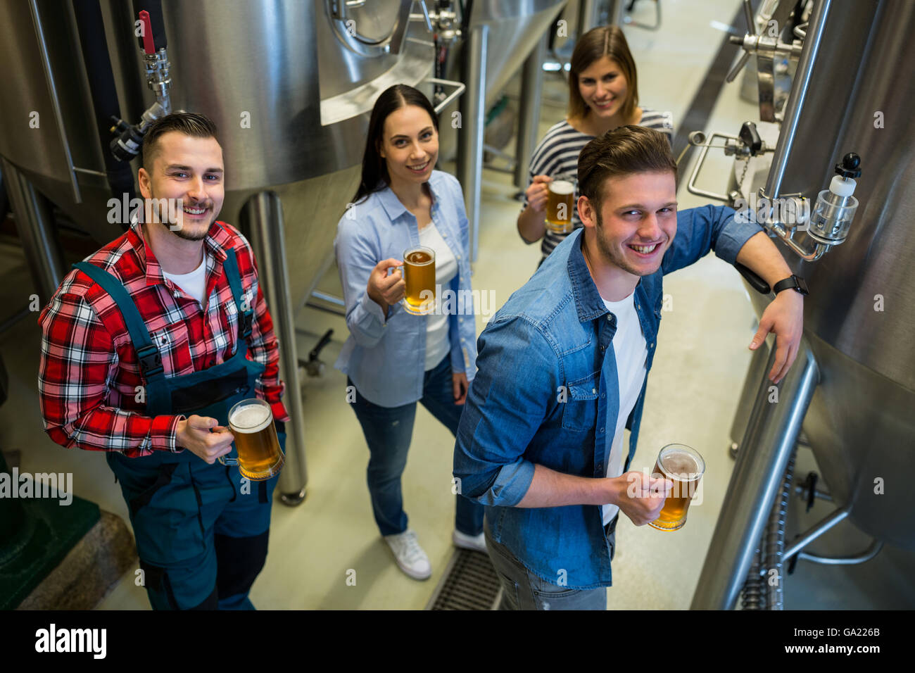 Brewers holding glass of beer standing at brewery Stock Photo - Alamy