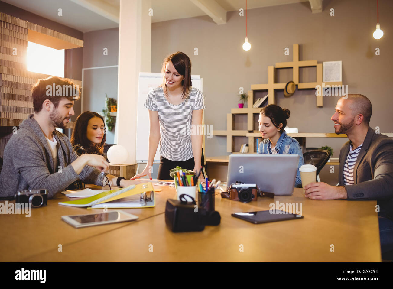 Female graphic designer having discussion with coworkers Stock Photo ...