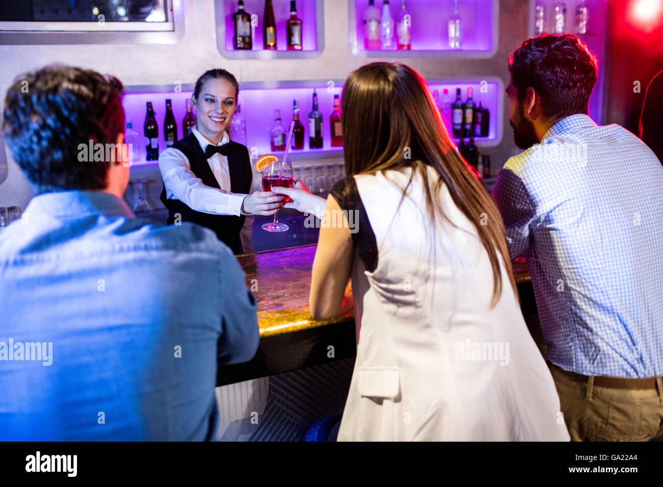 Barmaid serving drink to woman Stock Photo - Alamy