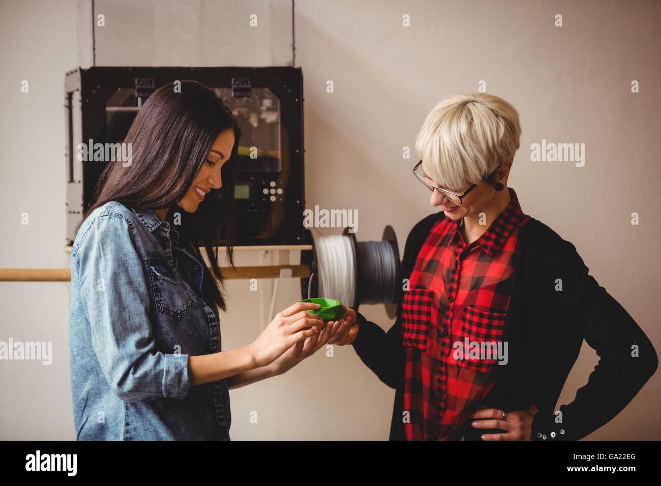 Female graphic designers having discussion on model Stock Photo - Alamy