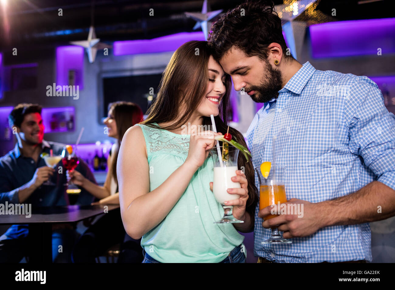 Couple embracing each other at bar counter while having cocktail Stock ...