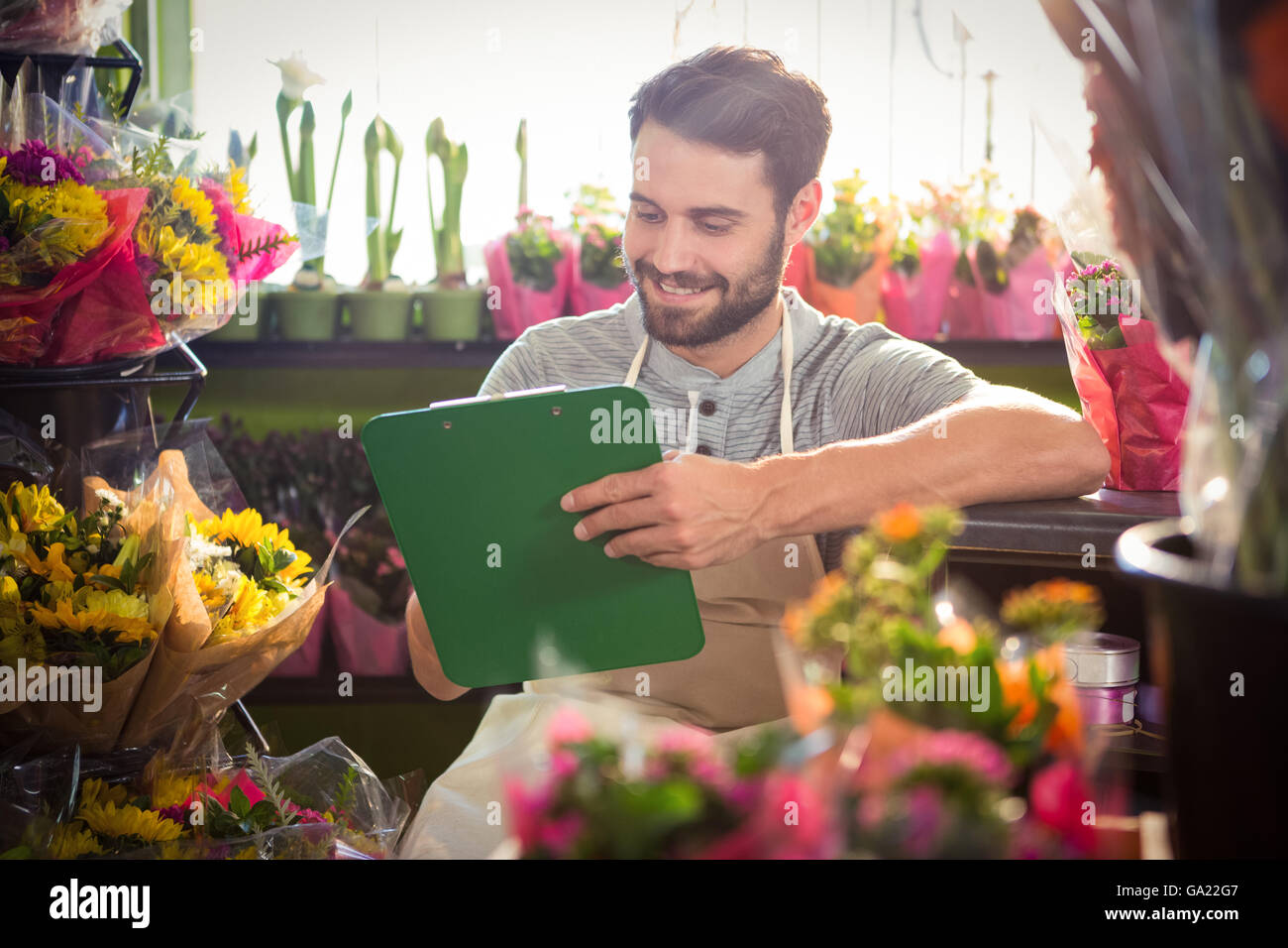Male florist writing and making notes Stock Photo - Alamy
