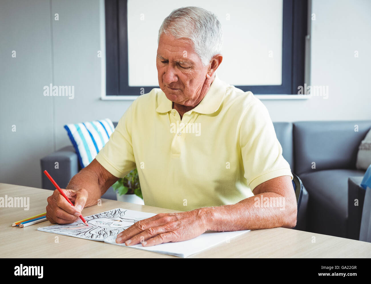 Senior man using a colouring book Stock Photo - Alamy