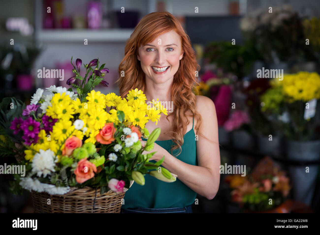 Happy female florist holding basket of flowers Stock Photo - Alamy