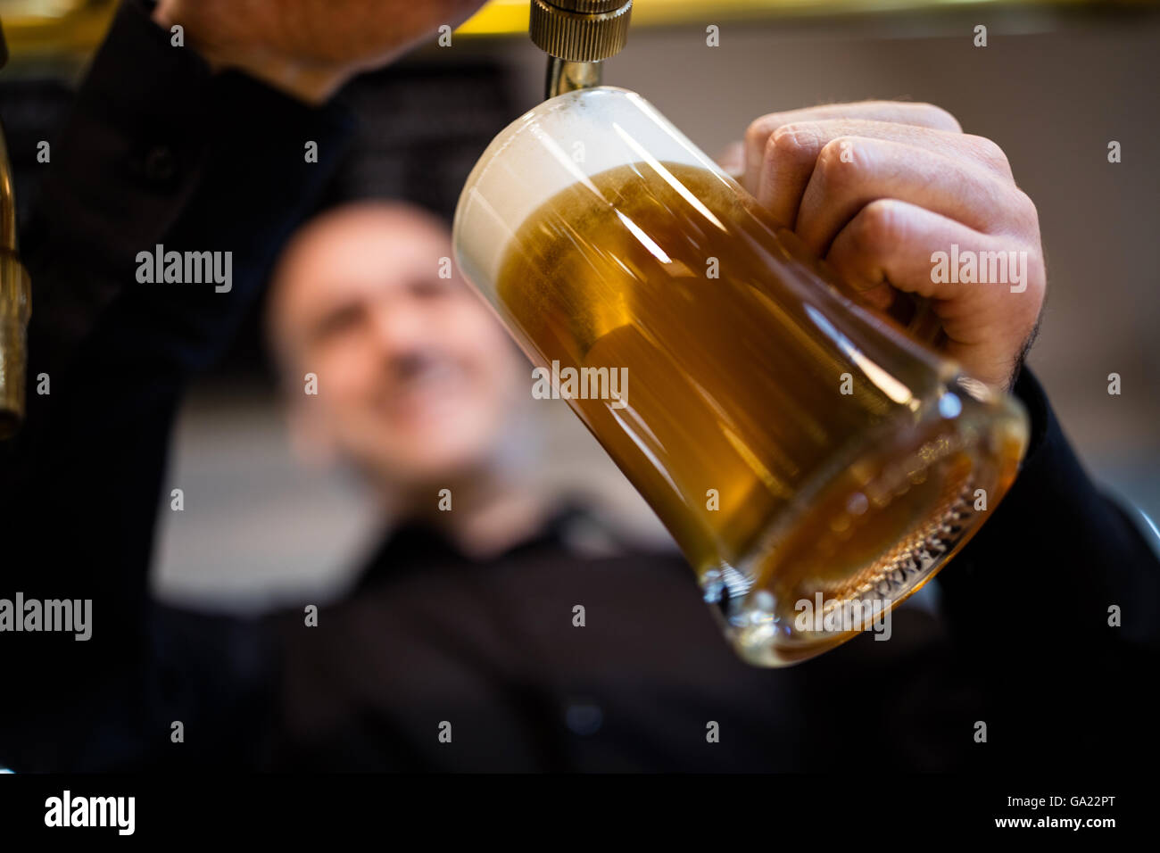 Brewer filling beer in beer glass from beer pump Stock Photo - Alamy
