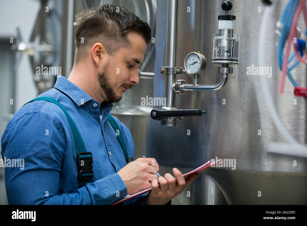 maintenance worker writing on clipboard Stock Photo - Alamy
