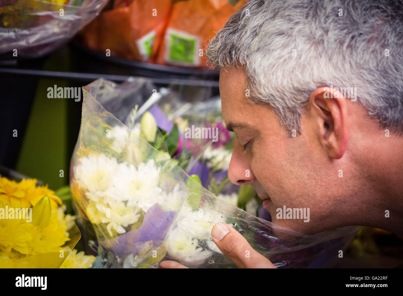 Male florist smelling flower Stock Photo - Alamy
