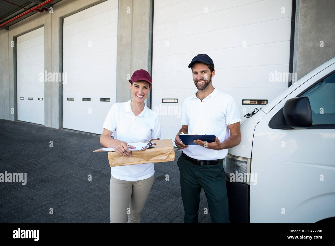 Portrait of delivery people are holding goods and posing Stock Photo ...