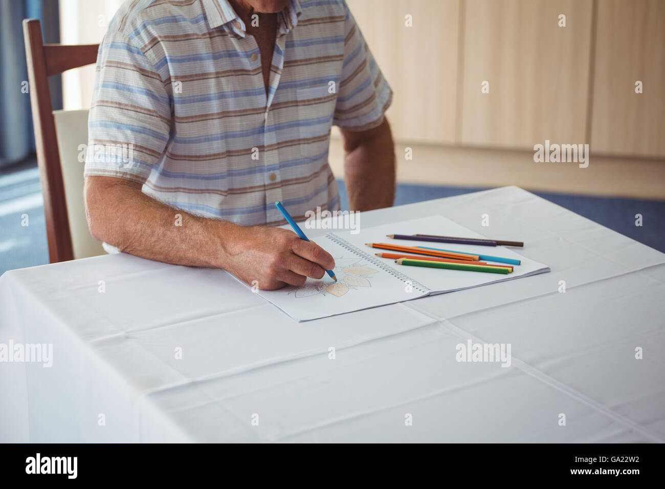 Senior man using a colouring book Stock Photo - Alamy