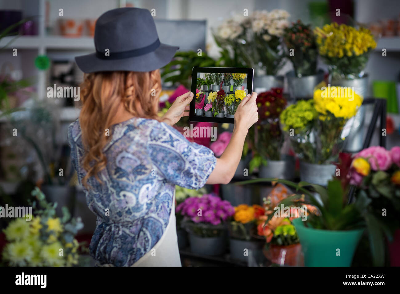 Female florist taking photograph of flowers Stock Photo - Alamy