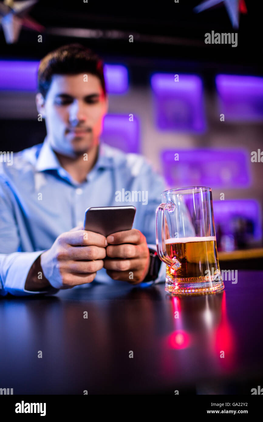 Man using mobile phone at bar counter Stock Photo - Alamy