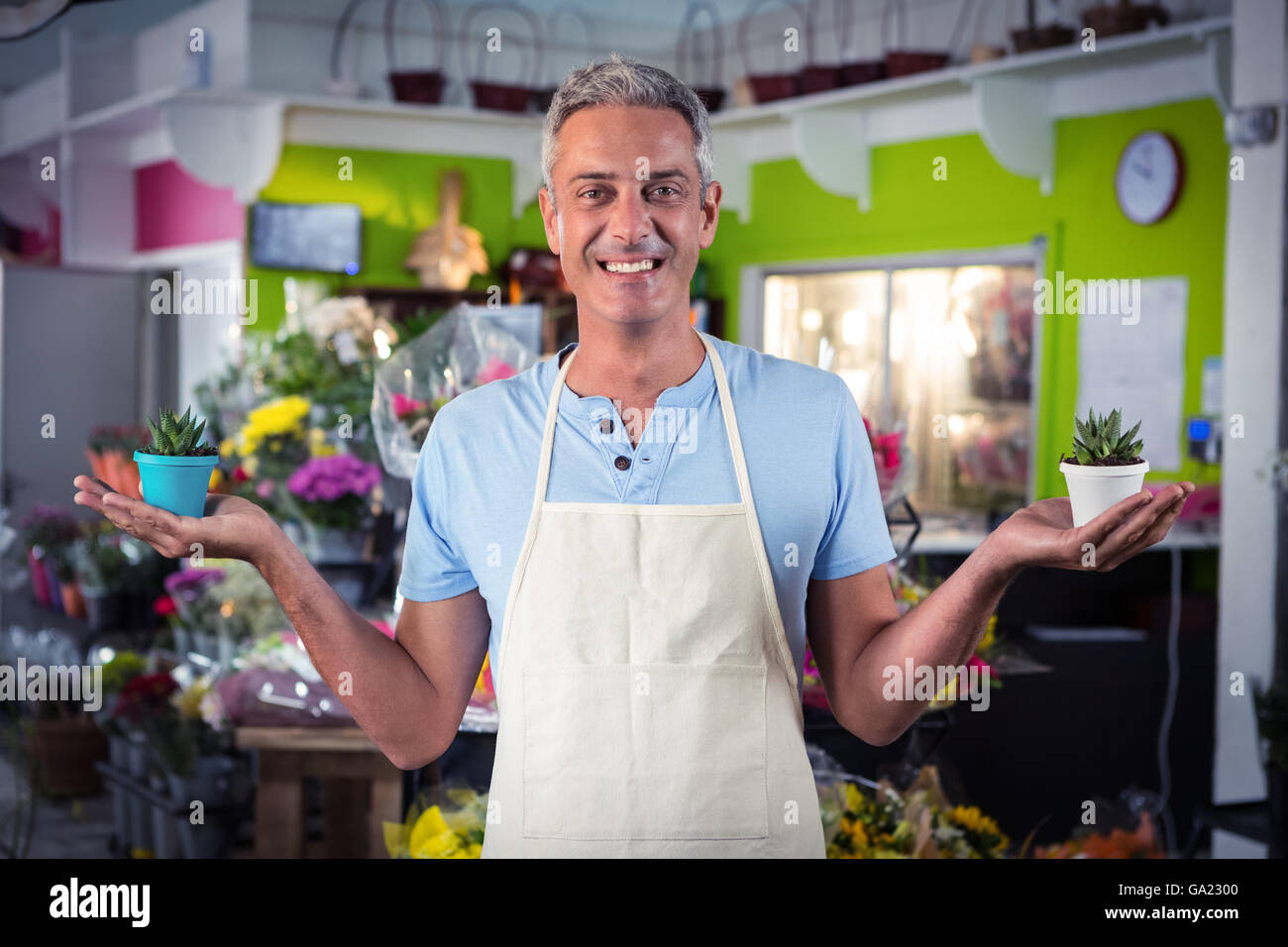 Male florist holding plant pot at flower shop Stock Photo - Alamy