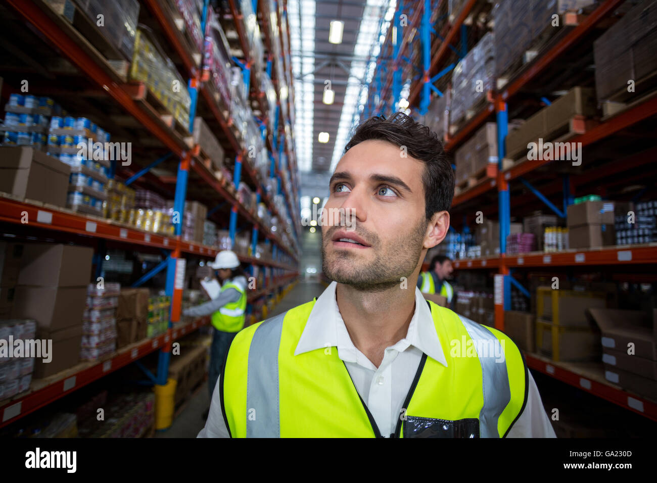 Worker in warehouse looking up Stock Photo - Alamy
