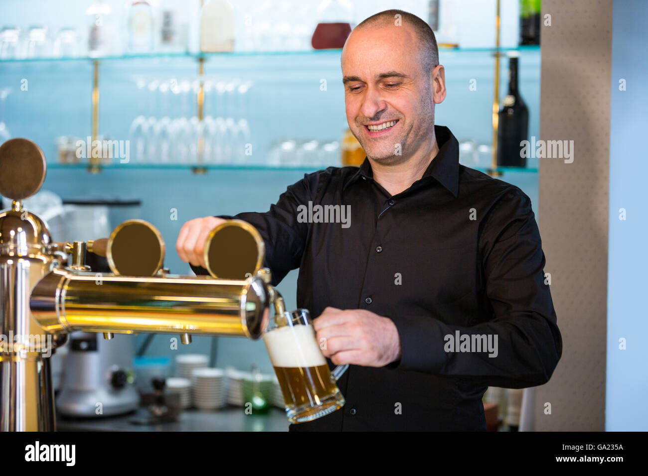 Bar tender filling beer from bar pump Stock Photo - Alamy
