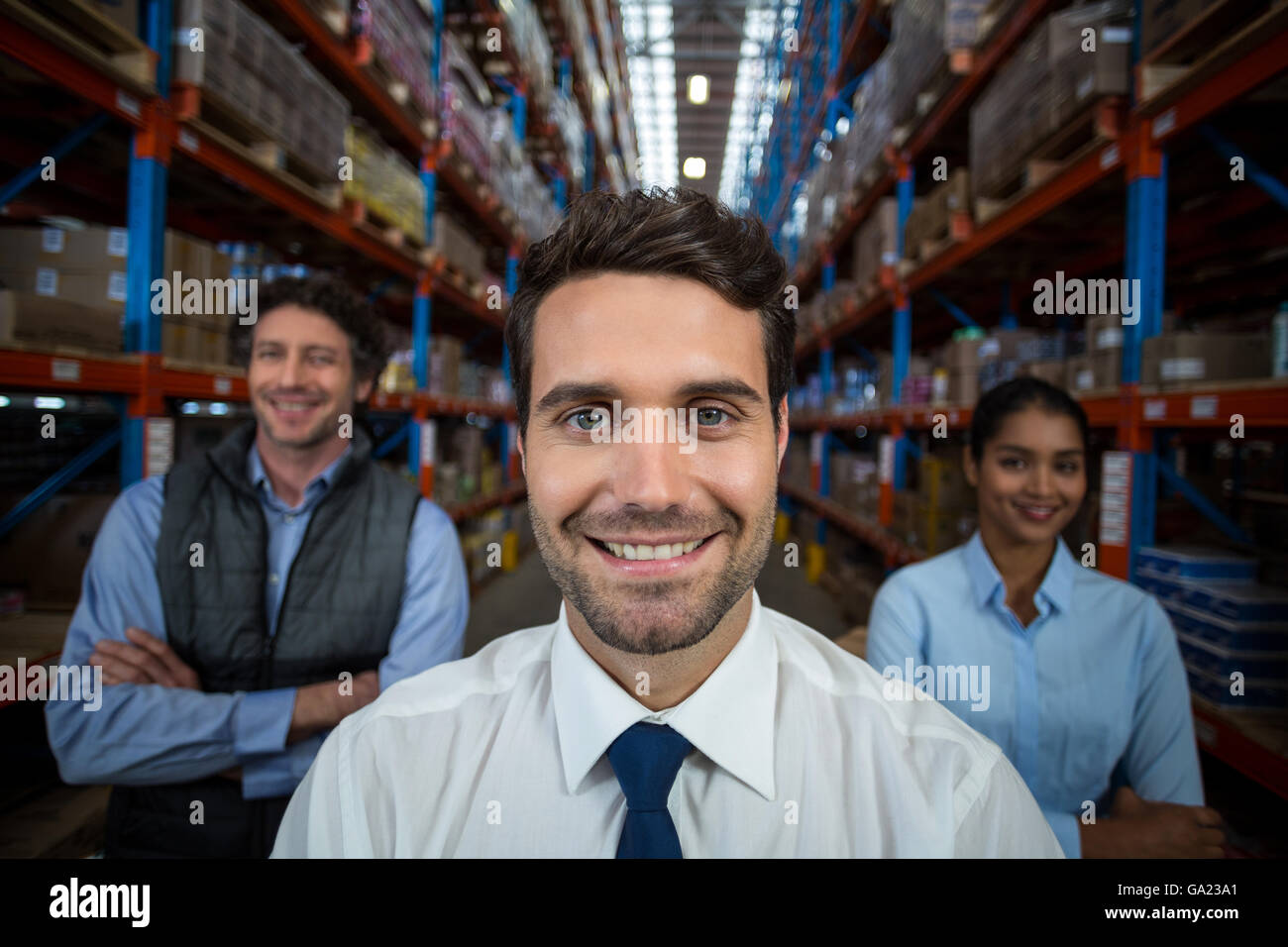 Focus of happy manager posing face to the camera with his colleagues ...