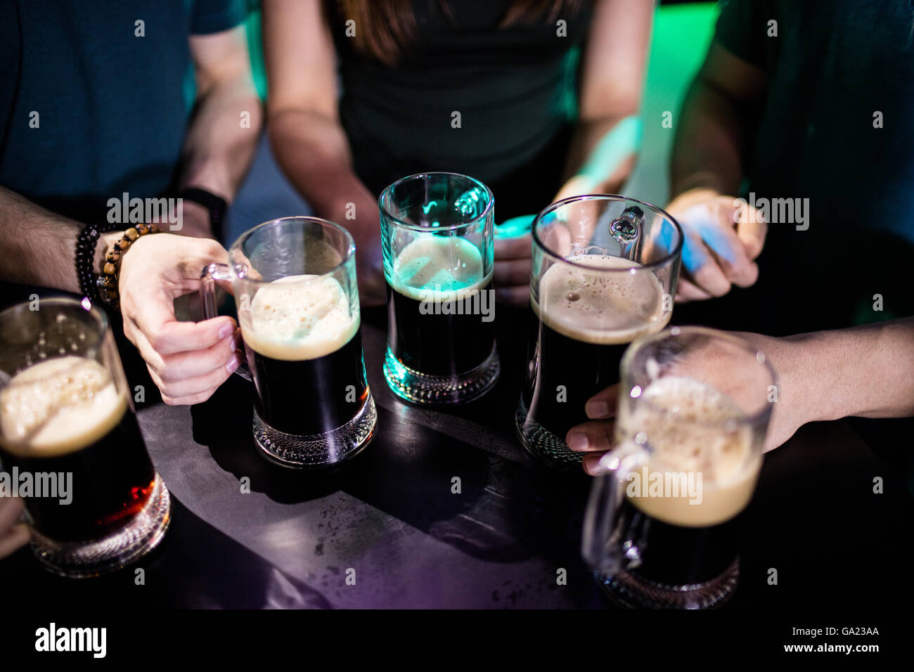 Group of friends holding beer mugs Stock Photo - Alamy