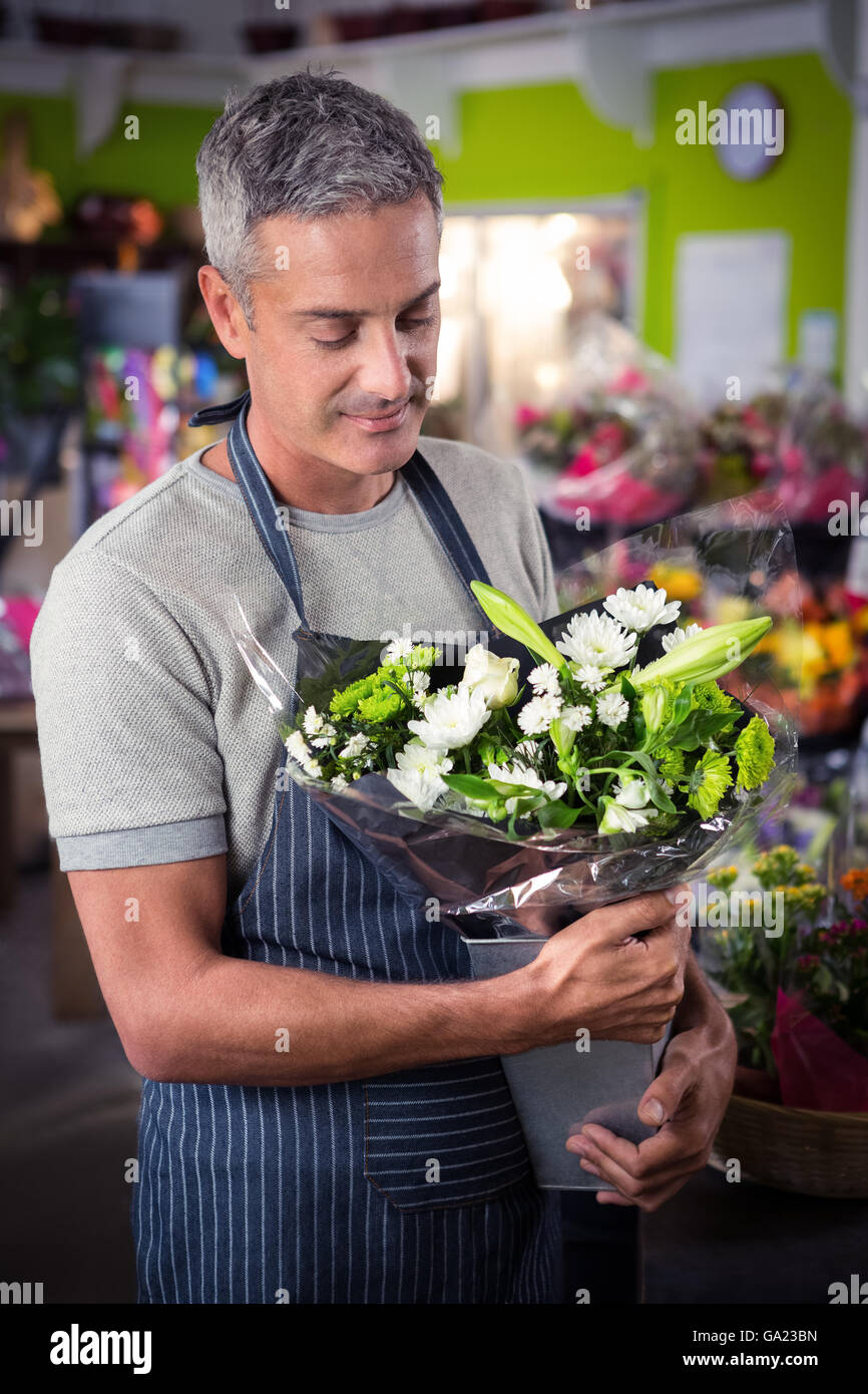 Male florist holding bunch of white flower in vase Stock Photo - Alamy