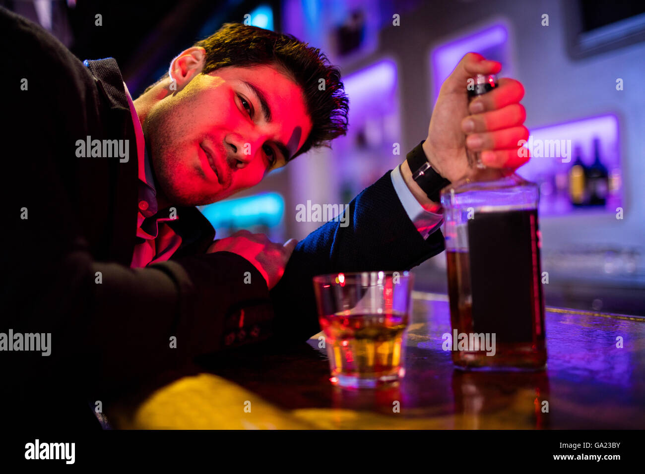 Drunken man leaning on bar counter Stock Photo - Alamy