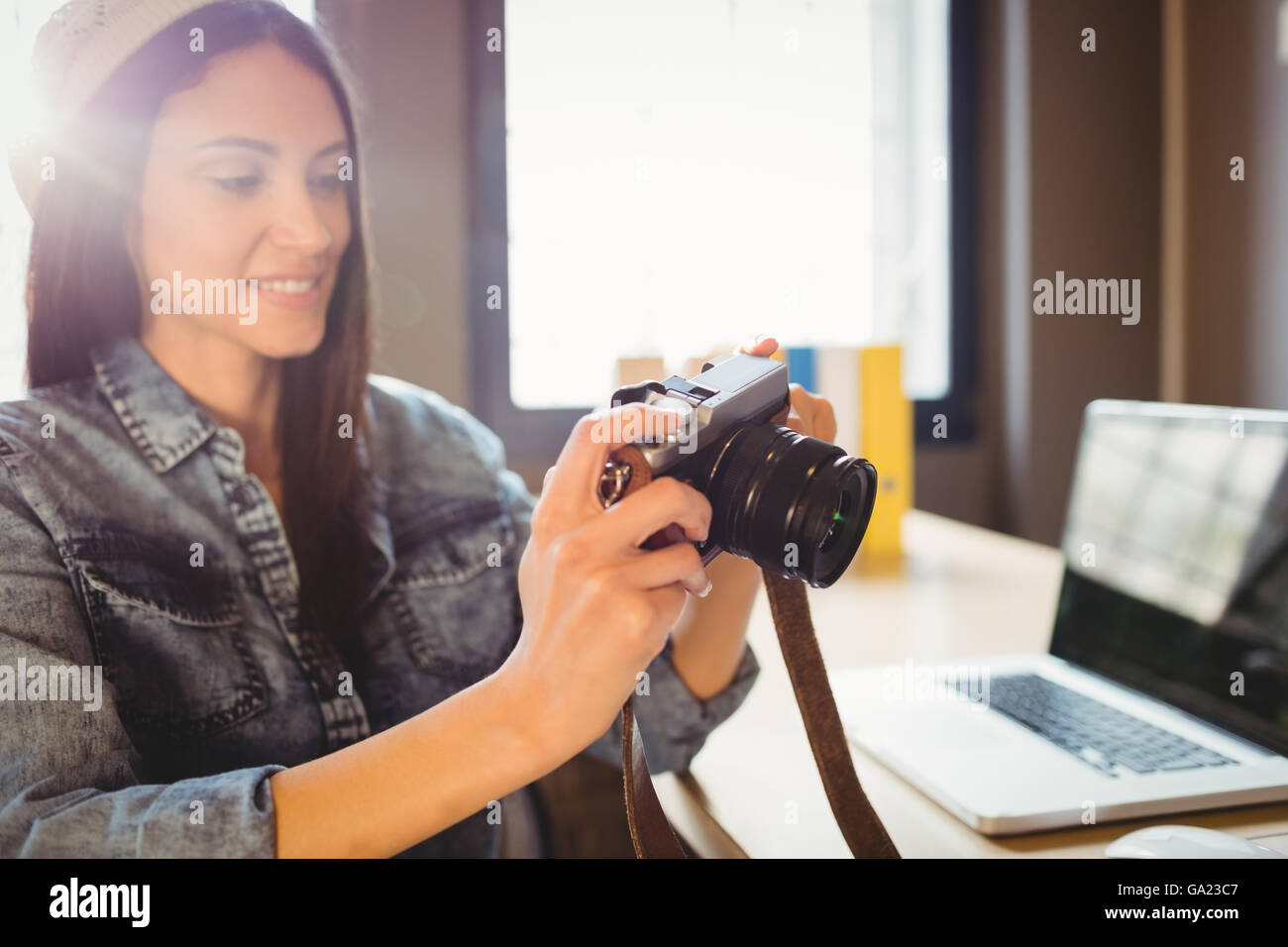 Graphic designer looking at pictures in digital camera Stock Photo - Alamy
