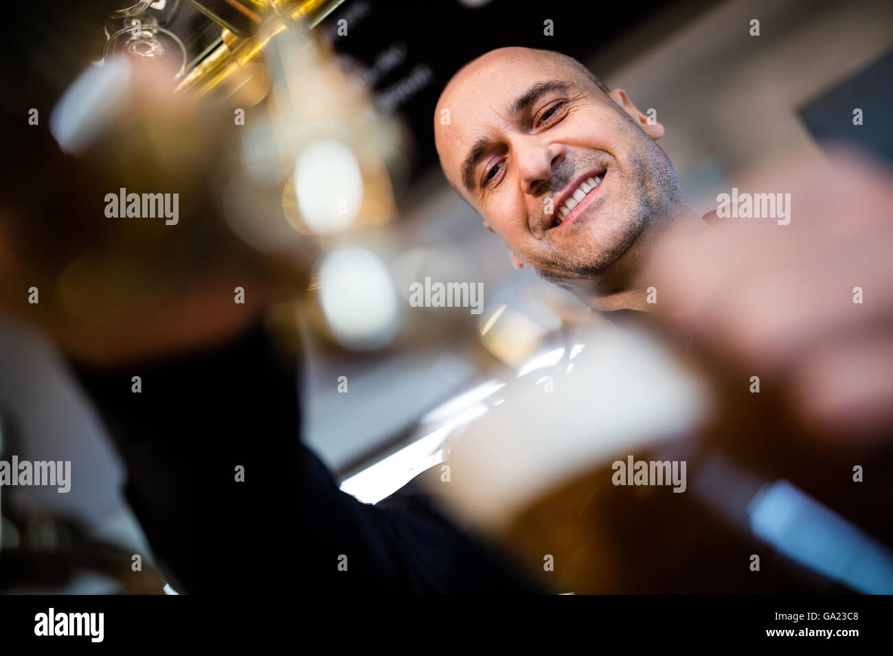 Brewer filling beer in beer glass from beer pump Stock Photo - Alamy