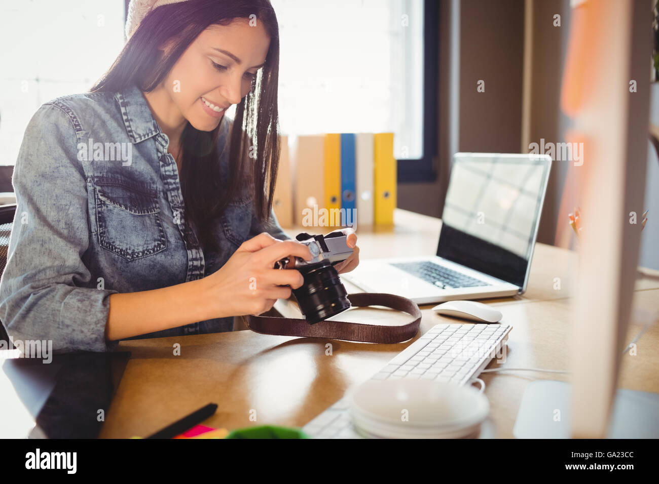 Graphic designer looking at pictures in digital camera Stock Photo - Alamy