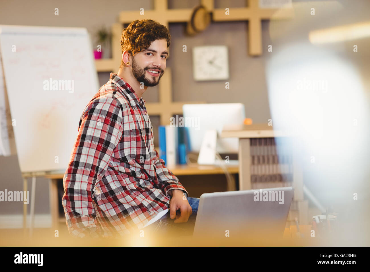 Portrait of graphic designer sitting with laptop Stock Photo - Alamy
