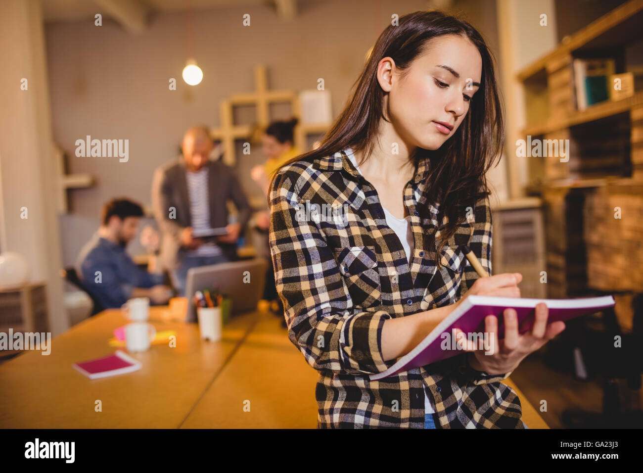 Graphic designer making notes in her diary Stock Photo - Alamy