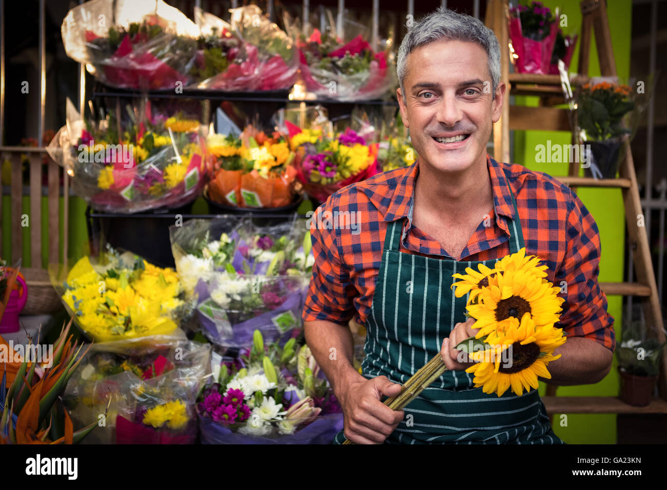 Male florist holding bunch of flowers at flower shop Stock Photo - Alamy