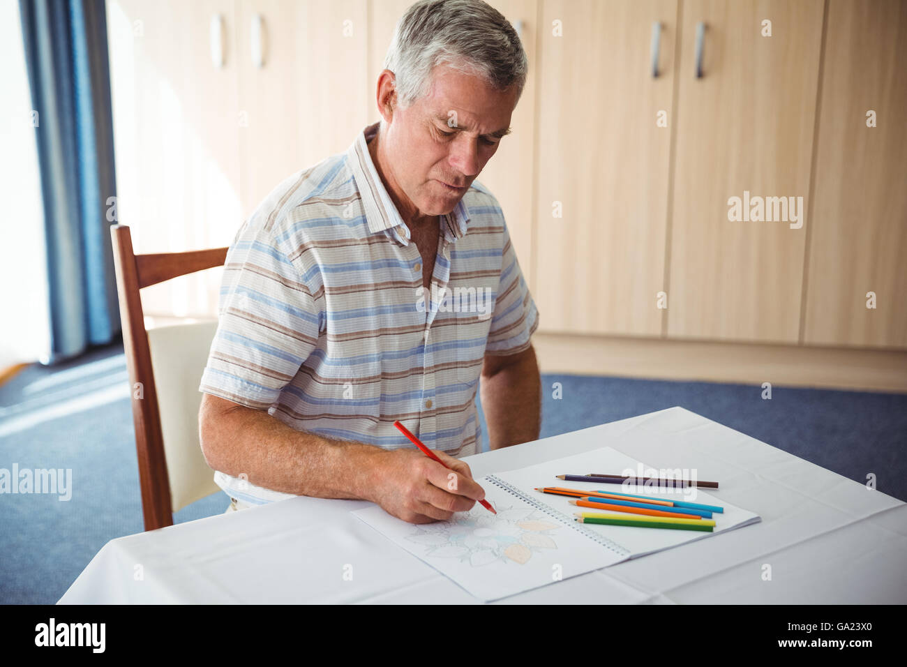 Senior man using a colouring book Stock Photo - Alamy