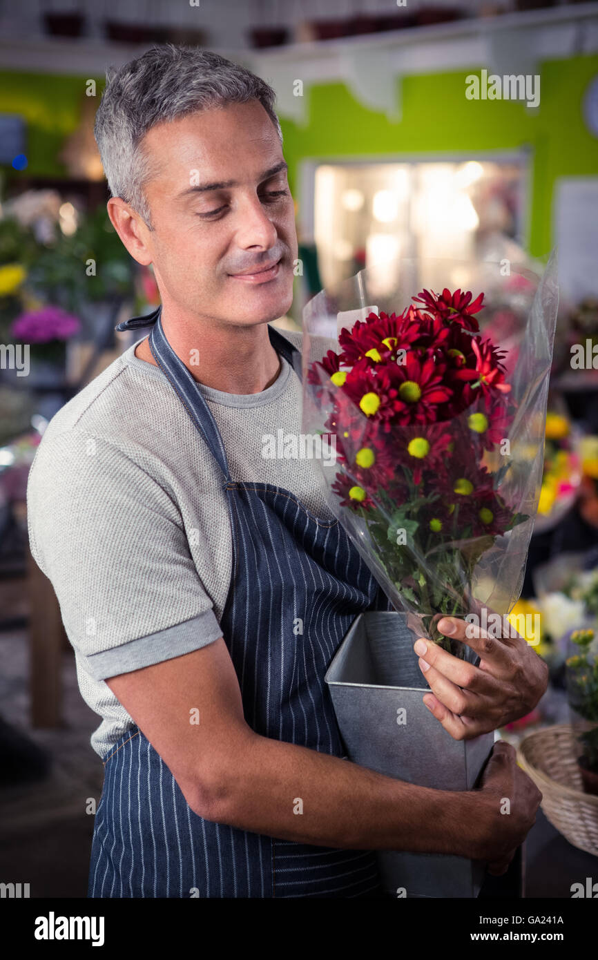 Male florist holding bunch of red sunflower in vase Stock Photo - Alamy