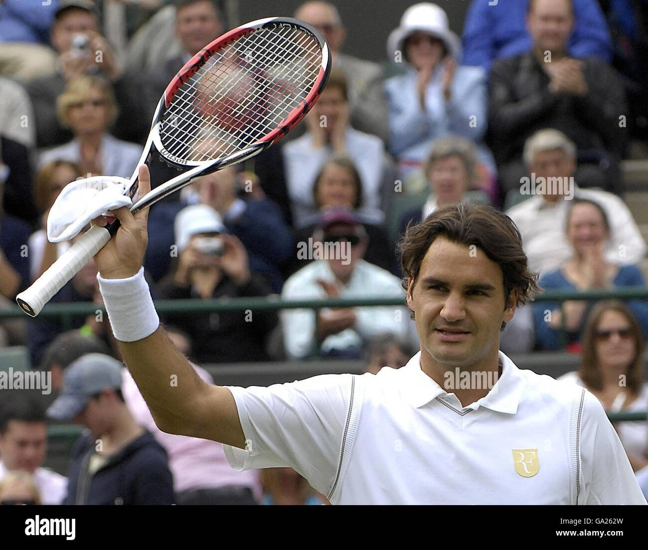 Switzerland's Roger Federer waves his racket to the crowd after his win ...