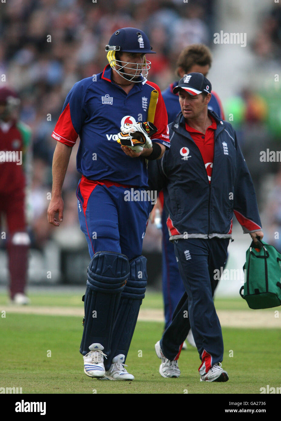 England's Kevin Pietersen leaves the field with physio Kirk Russell ...