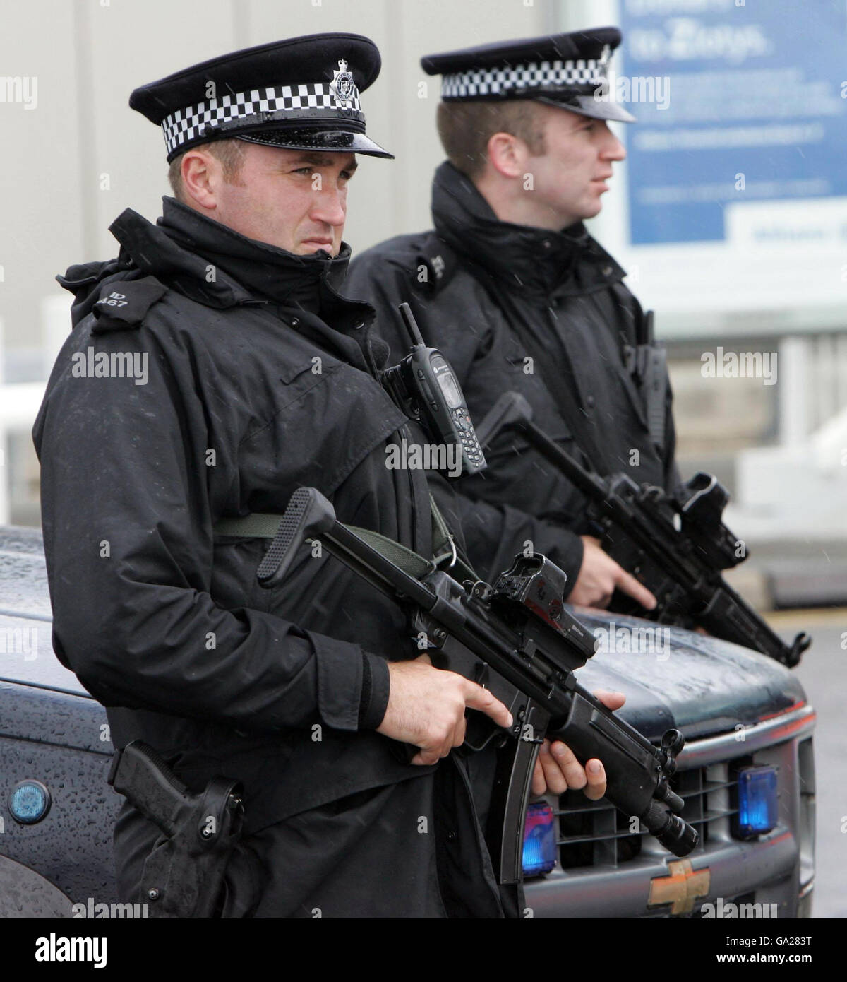 Armed policemen stand guard at the entrance to Terminal 4 at Heathrow ...