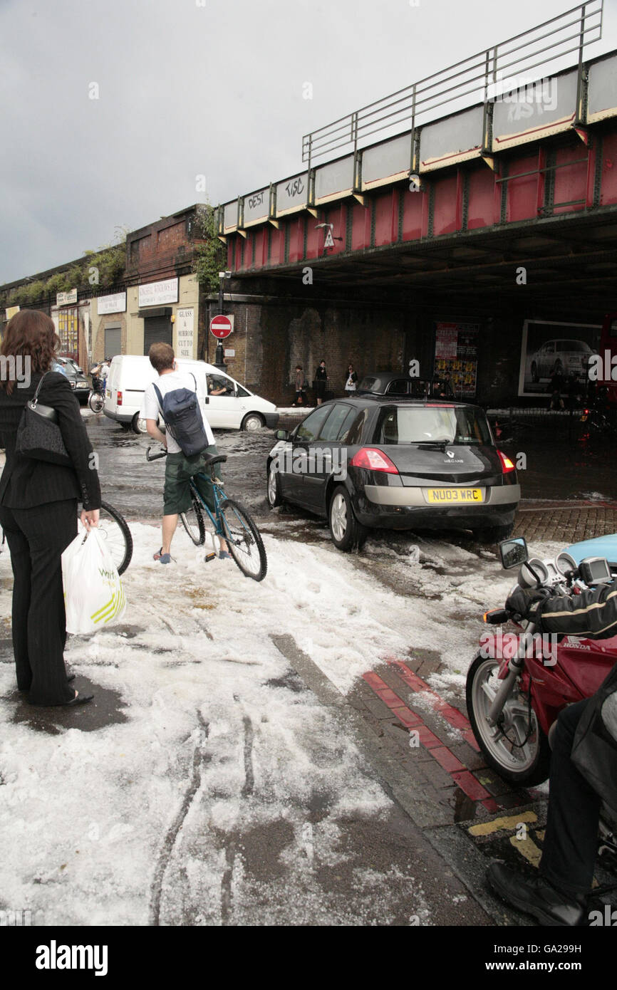 Vehicles and pedestrians struggle through the flood waters after a hail ...