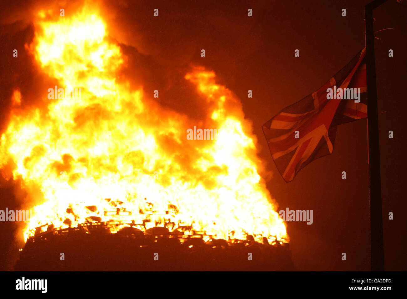 A Union Jack flies beside a bonfire on the Ballycraigy estate in Co ...